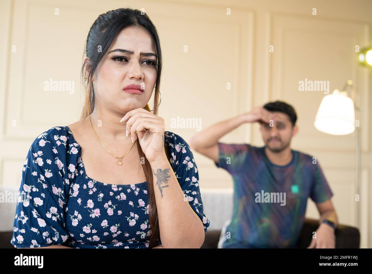 Irritated wife while talking with angry husband at home on couch ...