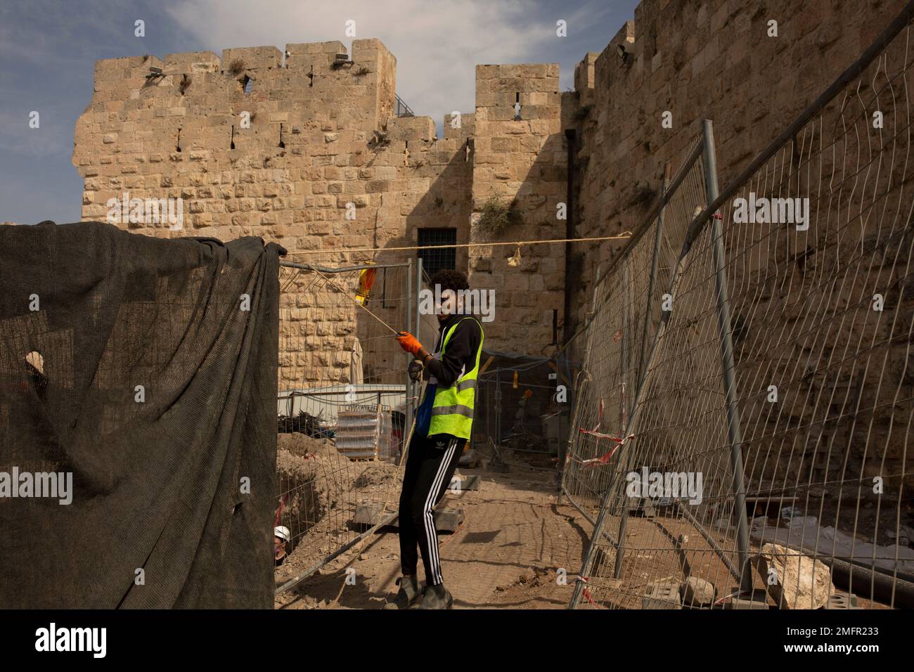 A worker places netting at a construction site inside the Tower of ...