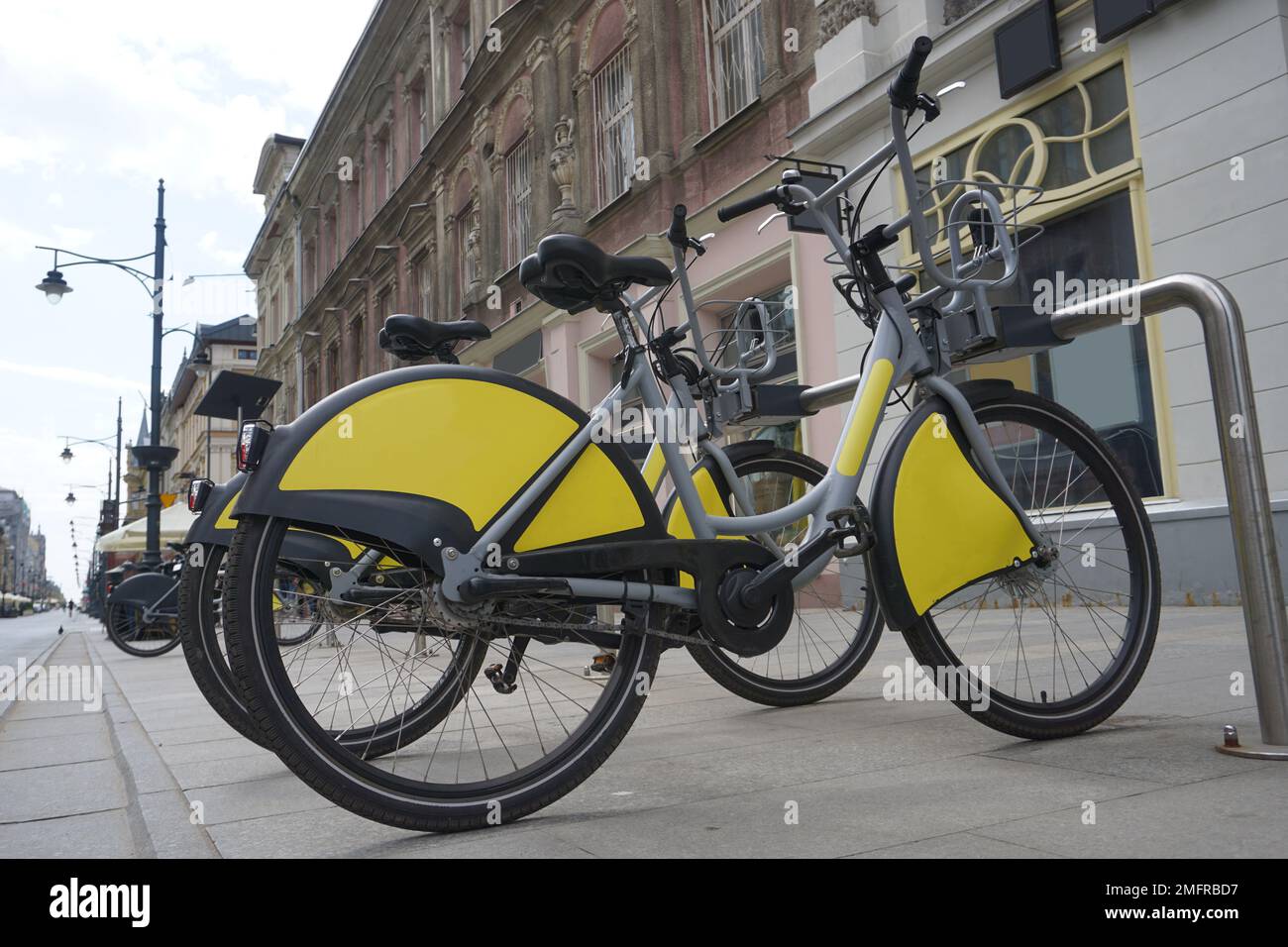 Yellow bikes standing in a row at city rental station Stock Photo - Alamy