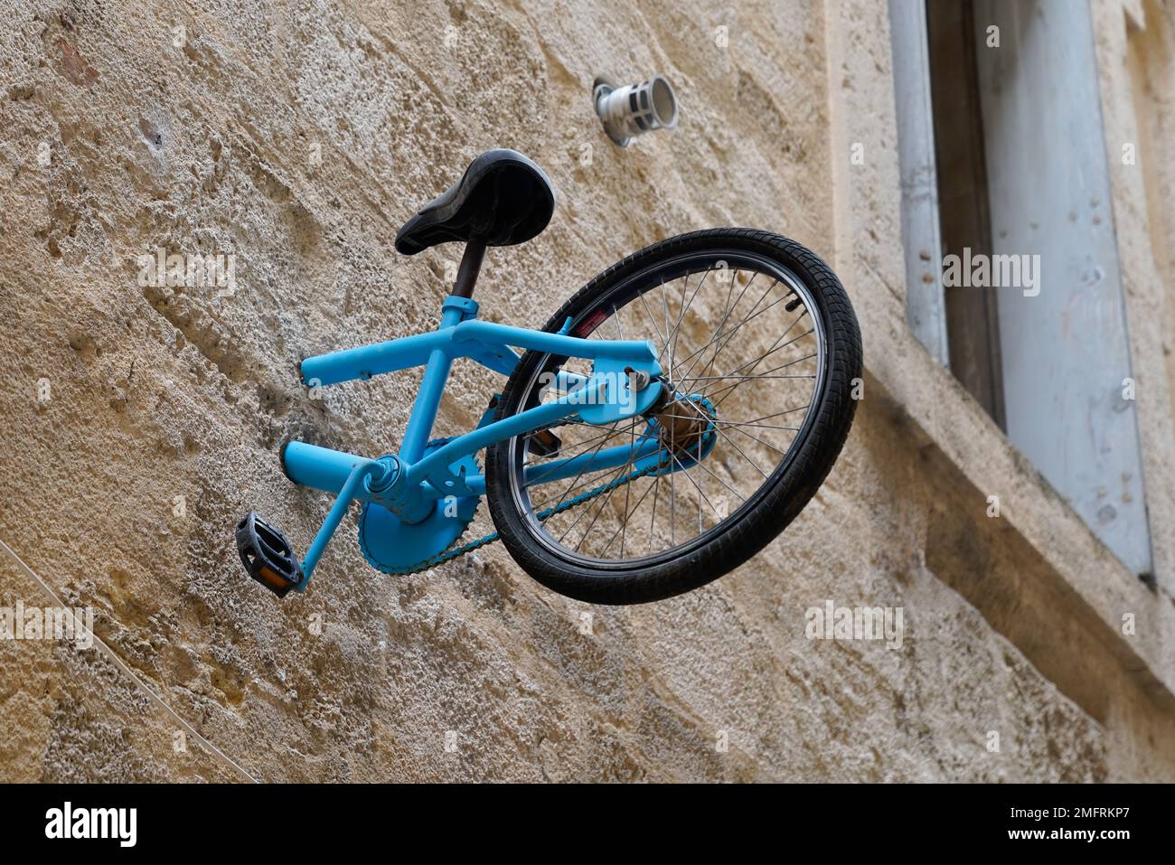 cut bike sculpture in a wall attached on facade city street Stock Photo ...