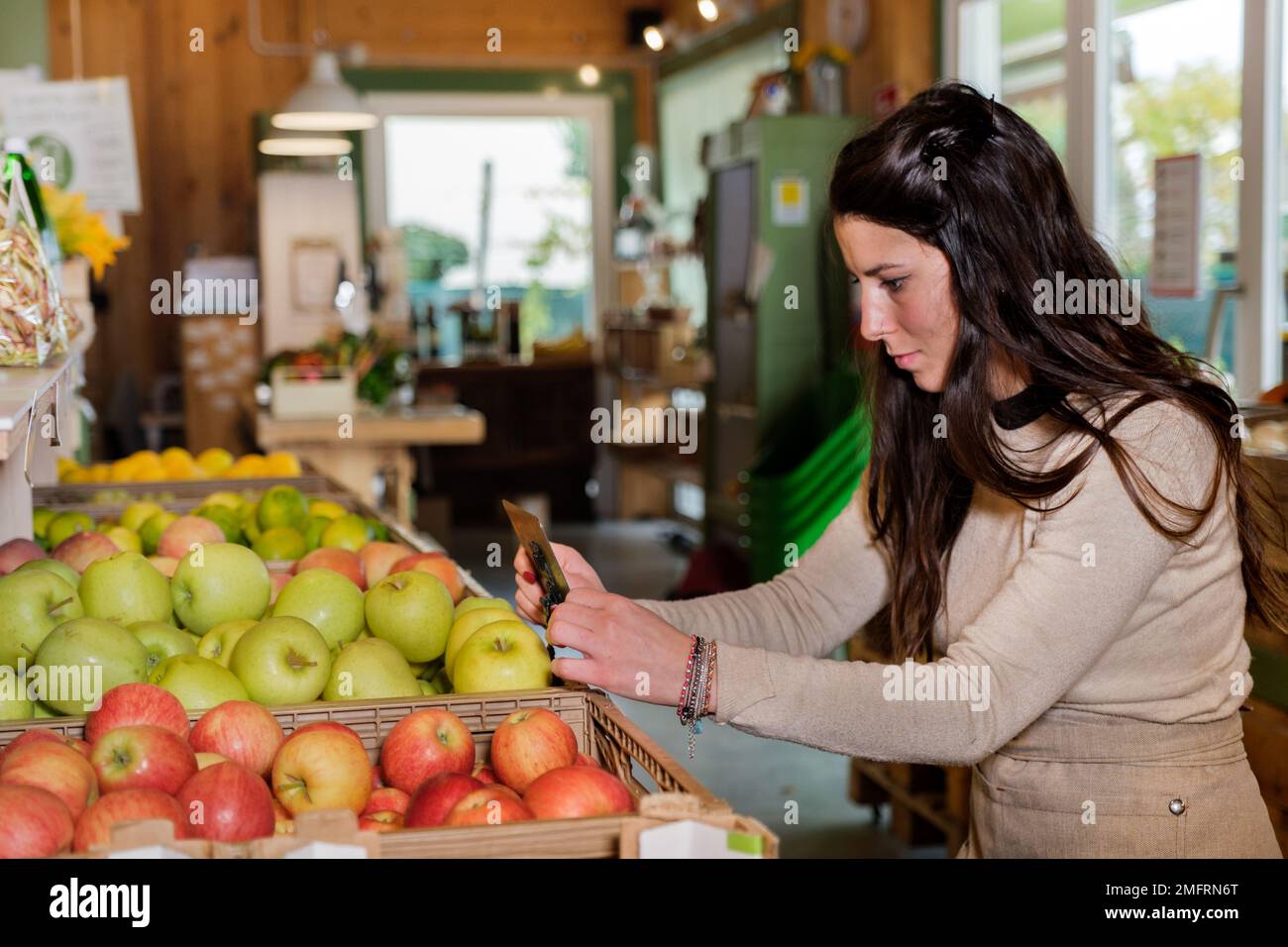 Saleswoman arranging the labels in greengrocer shop - Sales assistant ...