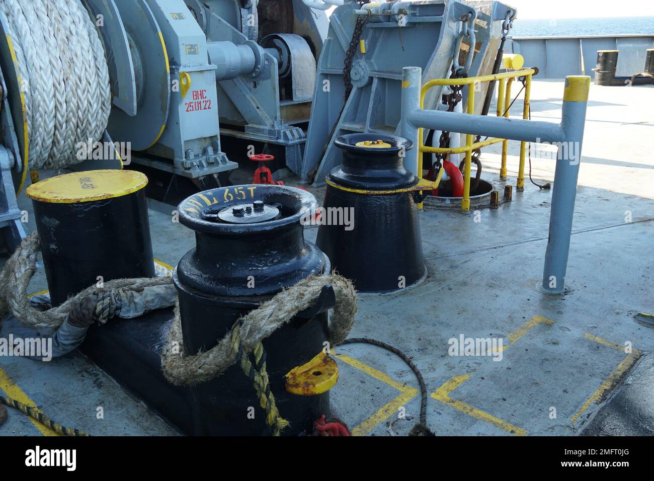 View on yellow and black painted bollards and mooring roller in forward ...