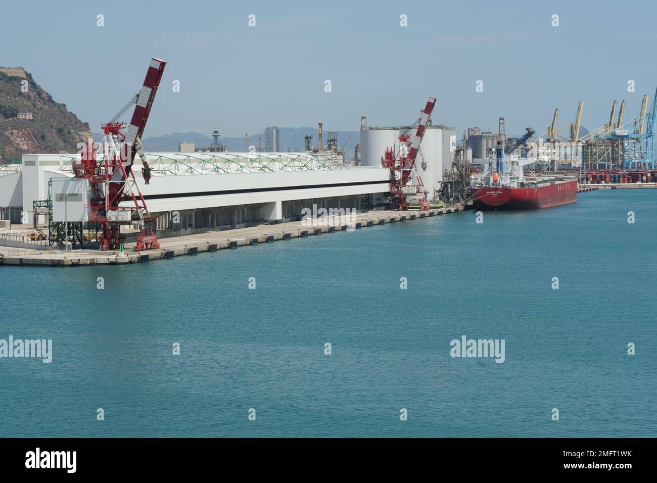 Huge two red and white ship loaders or cargo cranes situated on pier ...