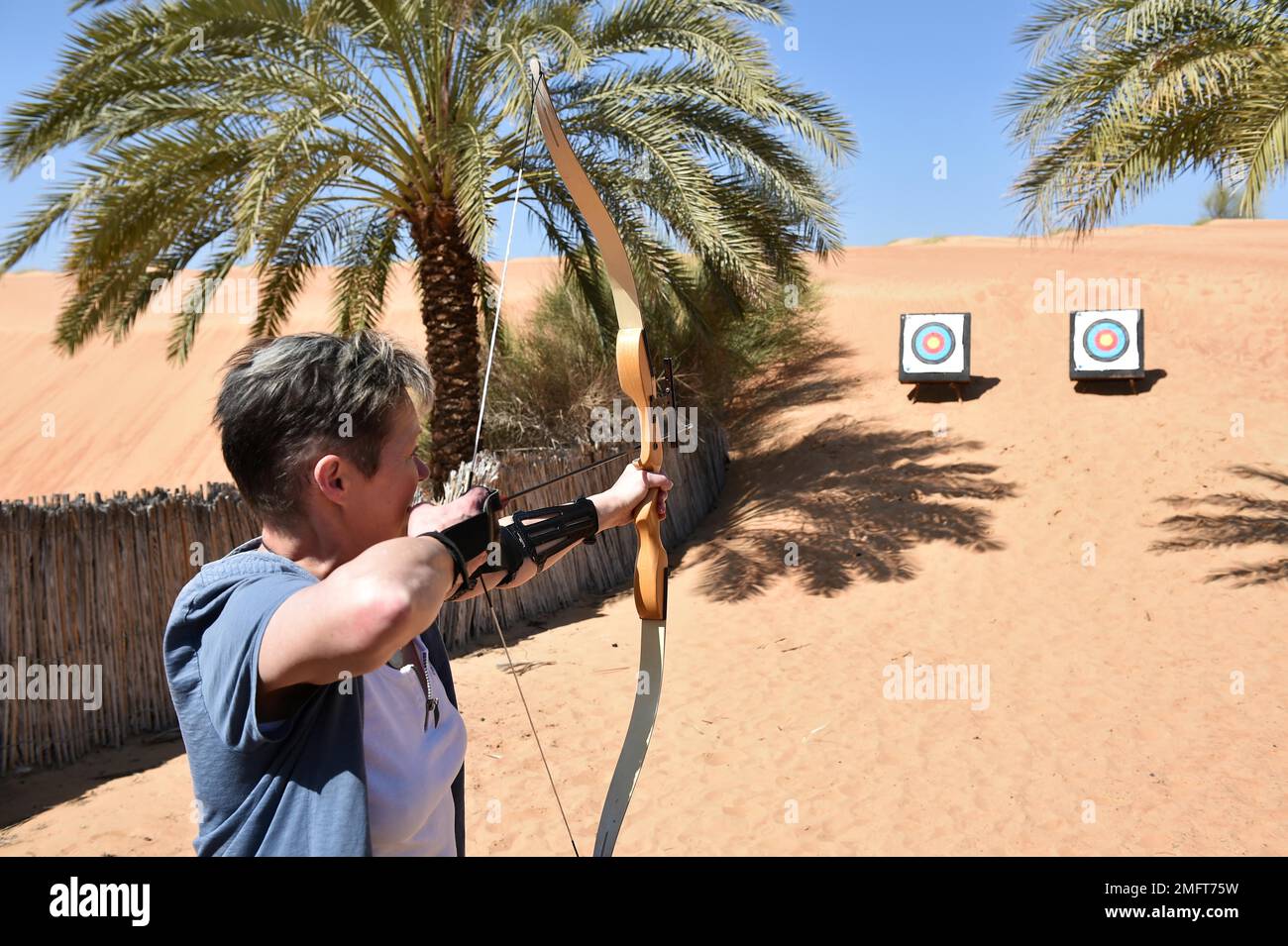 Woman doing archery in the desert of Dubai, United Arab Emirates Stock ...