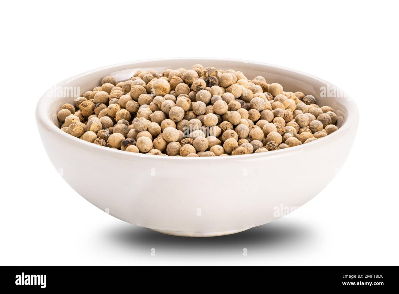 Side view closeup of white pepper in ceramic cup on white background ...