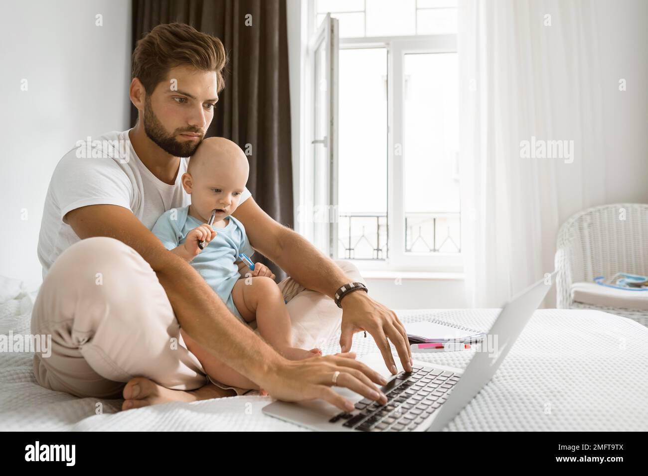 dad working laptop from home during quarantine with child. High ...