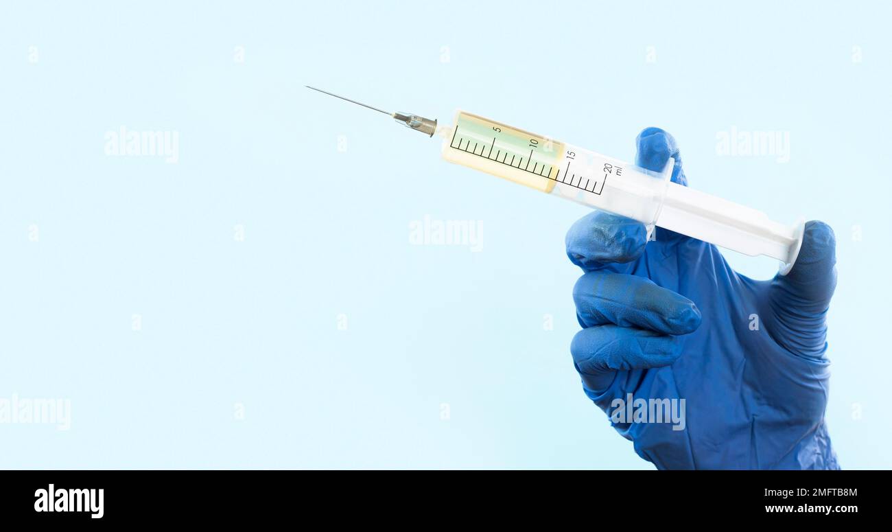 hand with latex glove holding syringe Stock Photo - Alamy