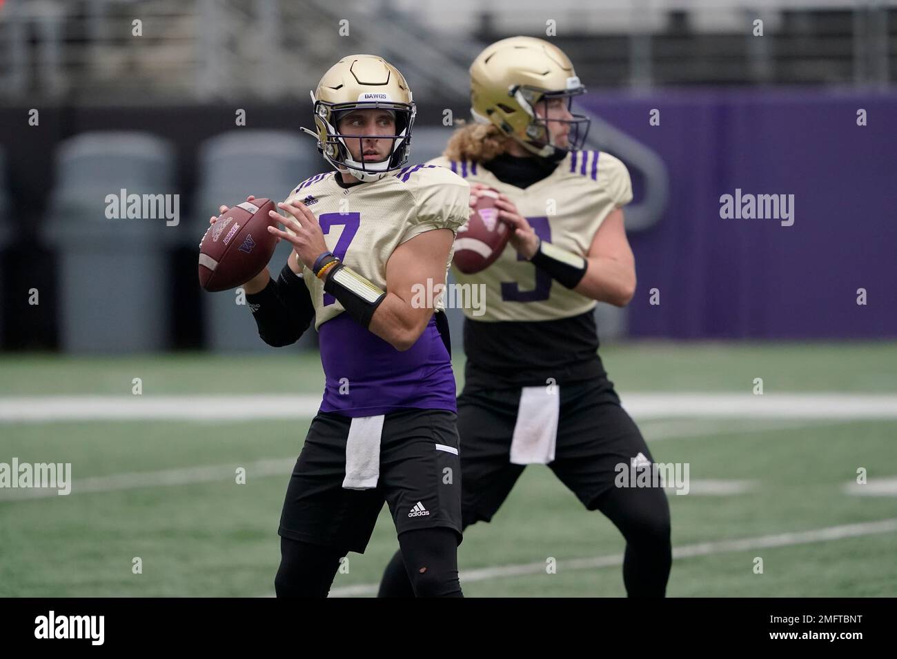 Washington quarterback Kevin Thomson, left, passes next to quarterback ...