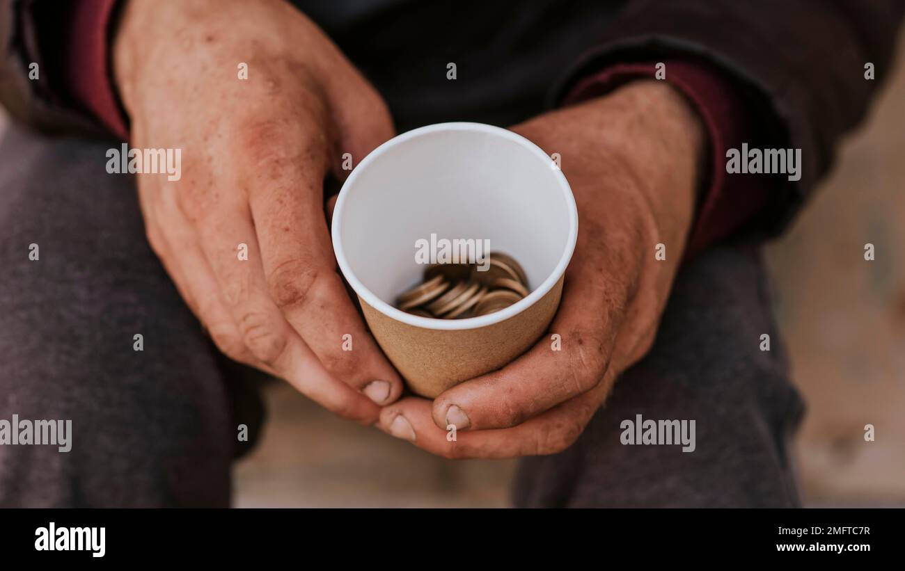 front view homeless man holding cup with coins Stock Photo - Alamy