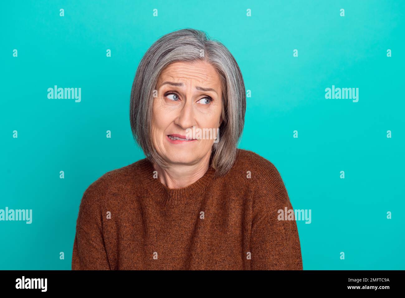 Photo of nervous aged person biting lips look interested empty space ...