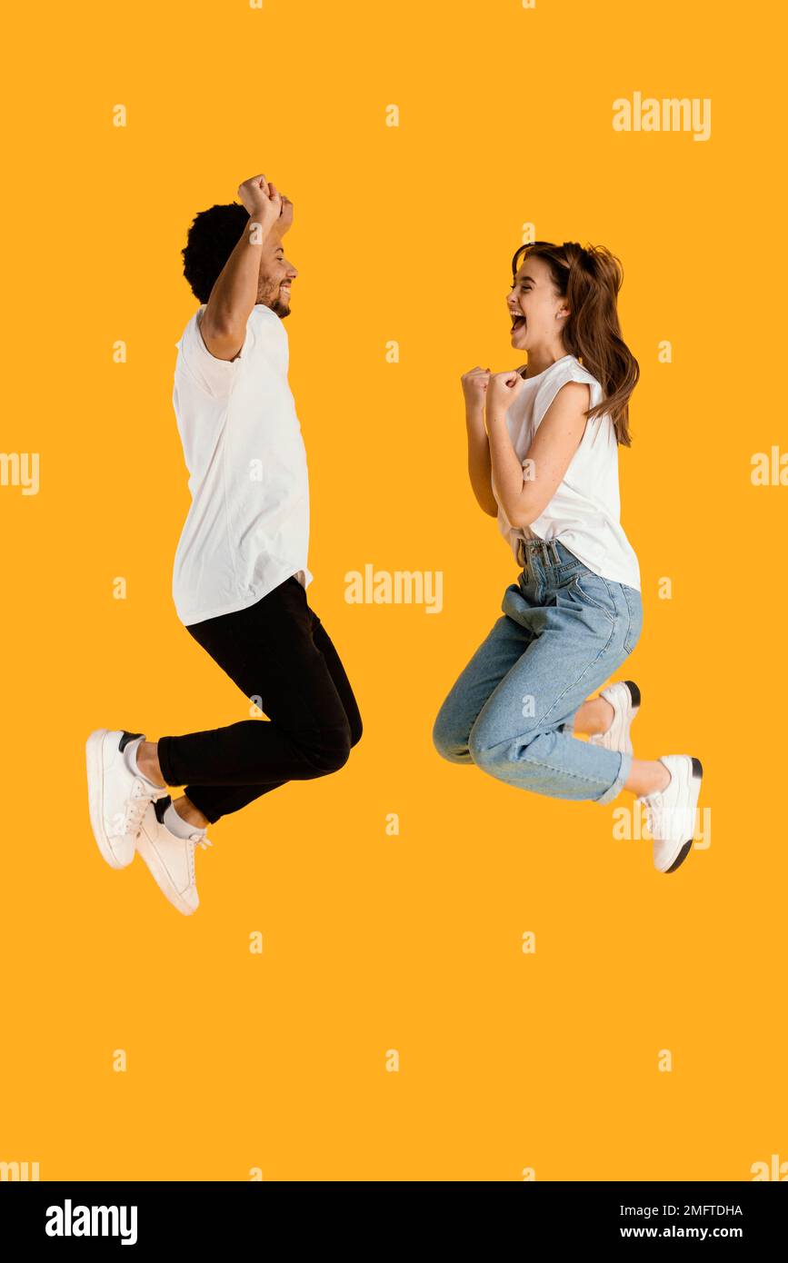 side view friends jumping Stock Photo - Alamy