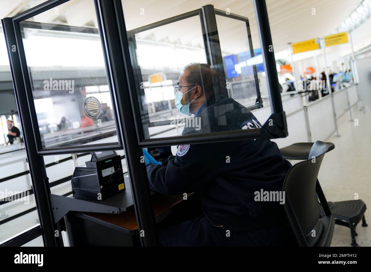 Transportation Security Administration personnel and travelers observe ...