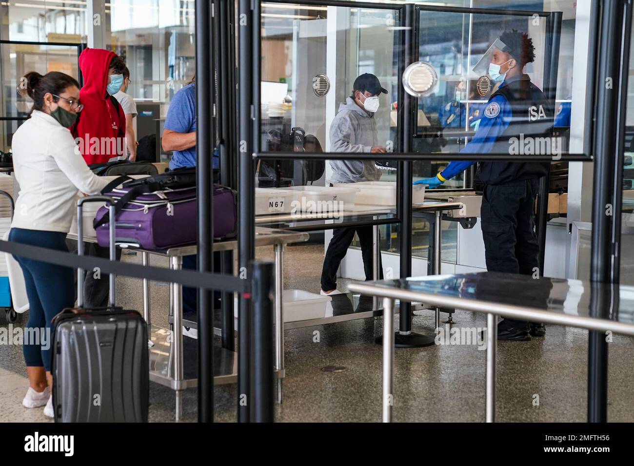 Transportation Security Administration personnel and travelers observe ...