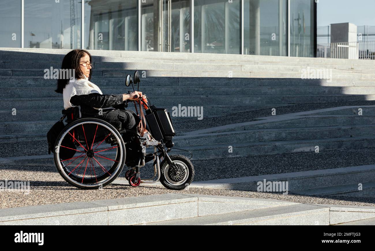 side view woman wheelchair street with copy space Stock Photo - Alamy