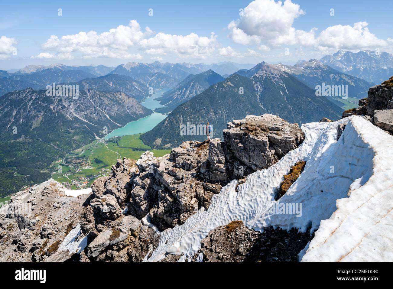 Hiker looking down from Thaneller to Plansee and eastern Lechtal Alps ...