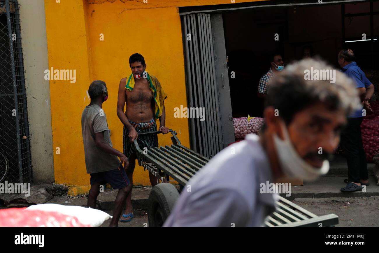 Sri Lankan daily wage laborers work at a wholesale market place in ...