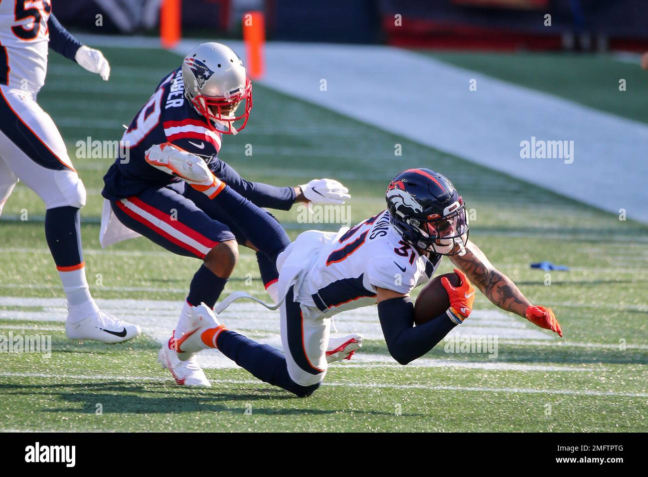 Denver Broncos safety Justin Simmons (31) is tackled by New England ...