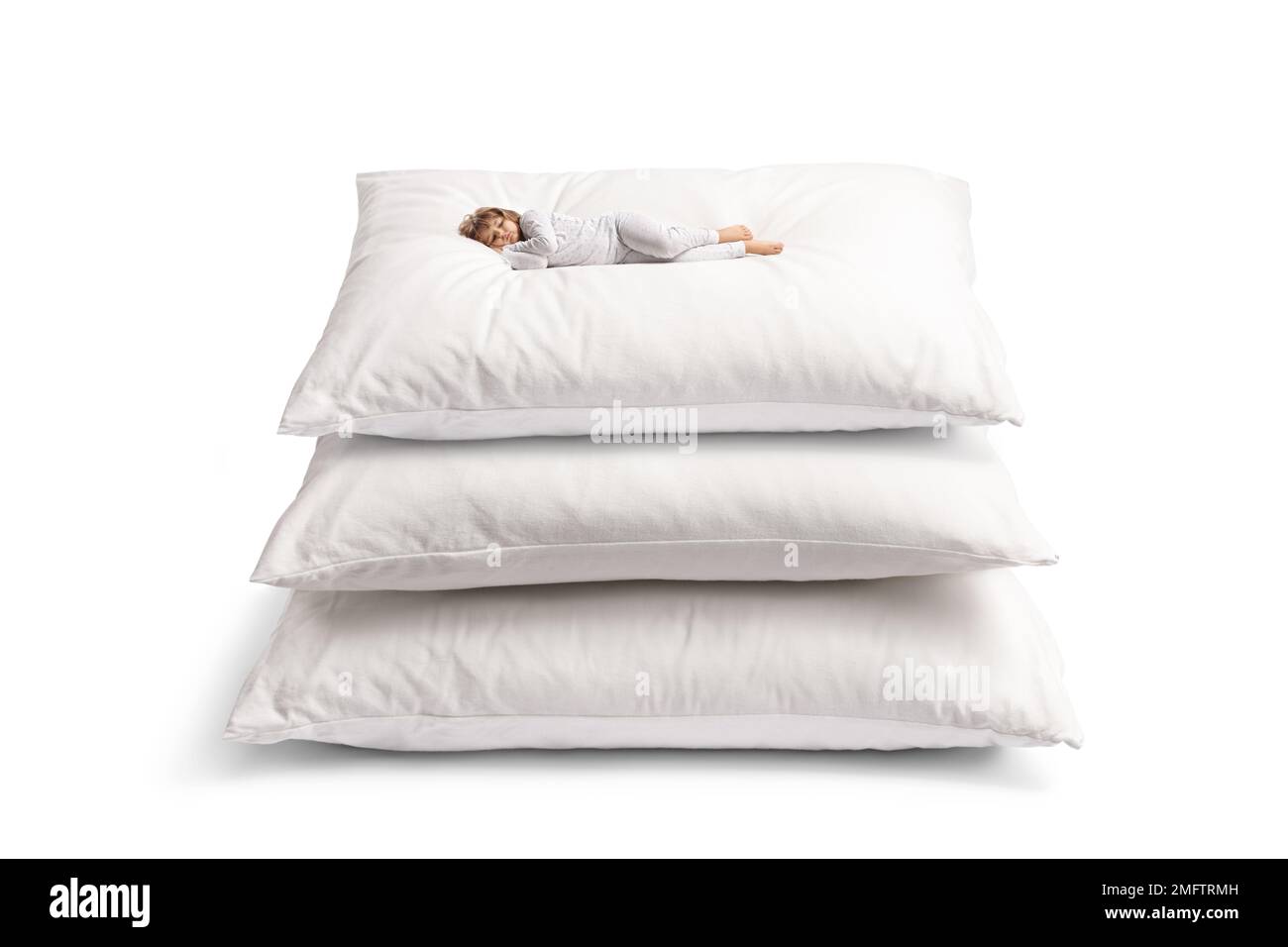 Little girl in pajamas sleeping over a pile of pillows isolated on ...