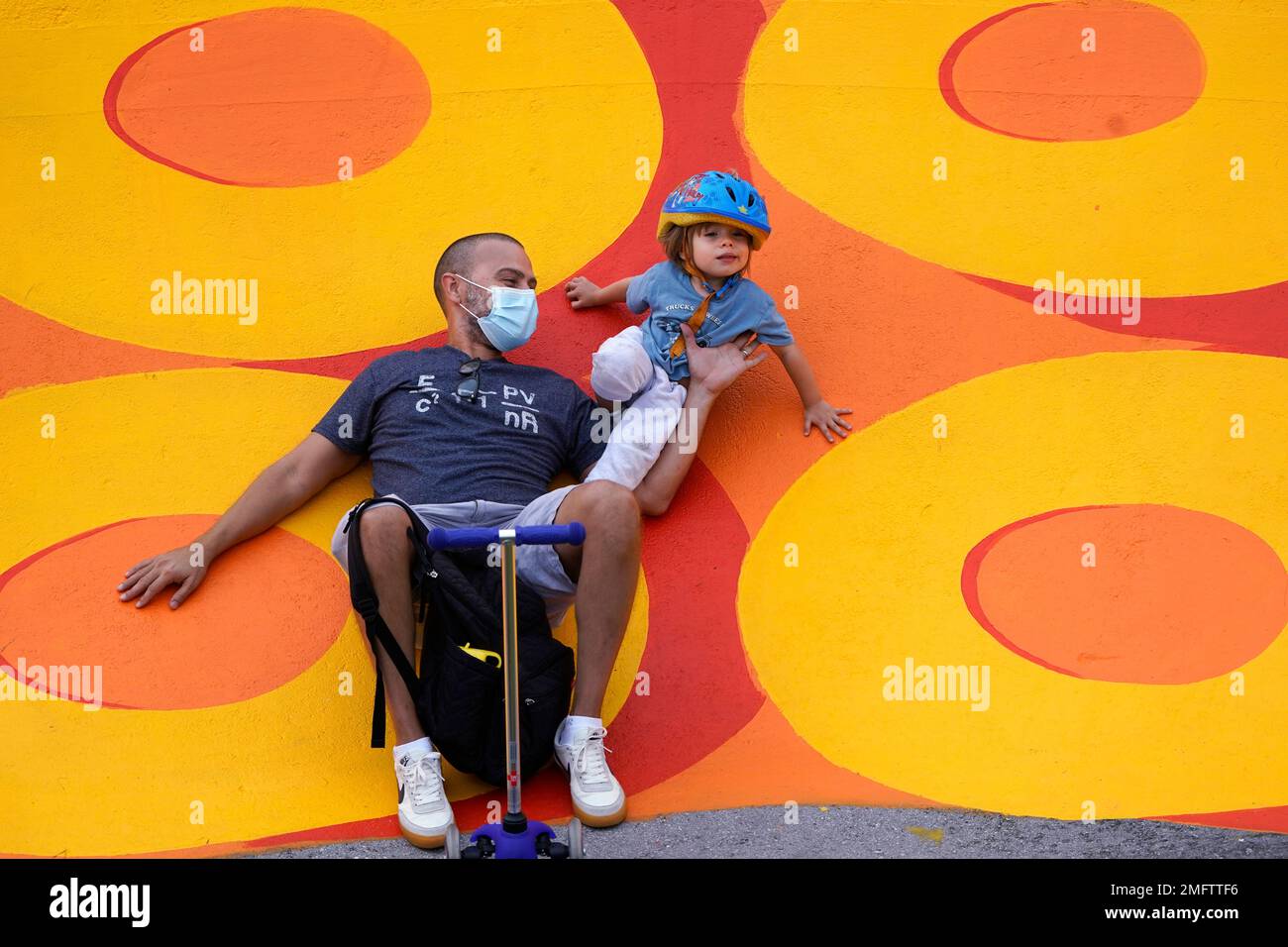 Manny Lopez and his son Matthew, 2, take a break as they try out the ...