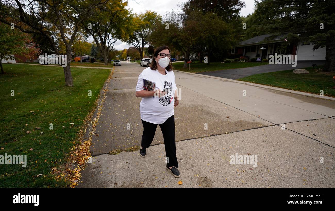 Lori Goldman walks between houses as she canvasses in Troy, Mich ...