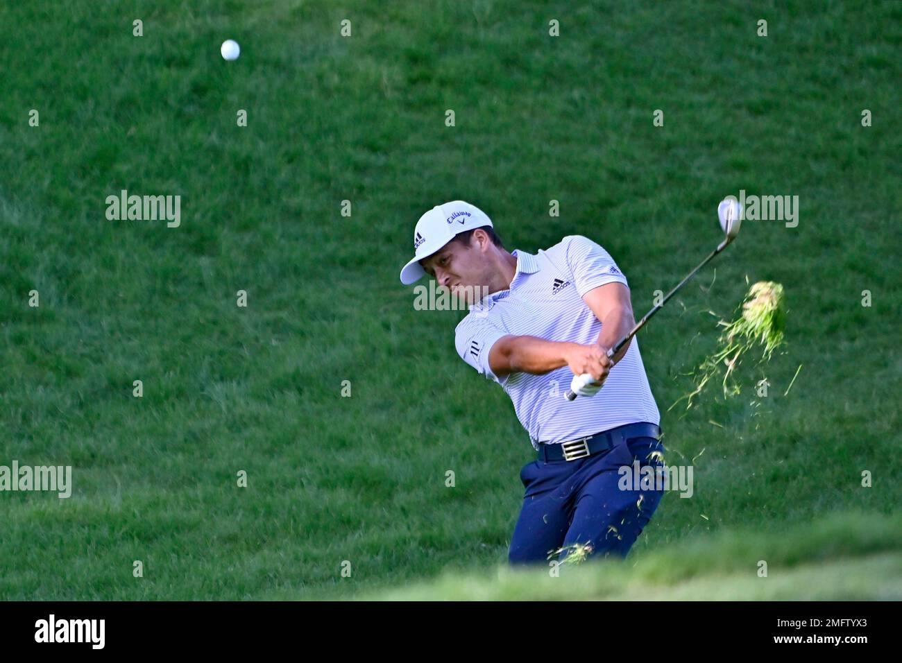 Xander Schauffele kicks up some grass as he makes a shot during the ...