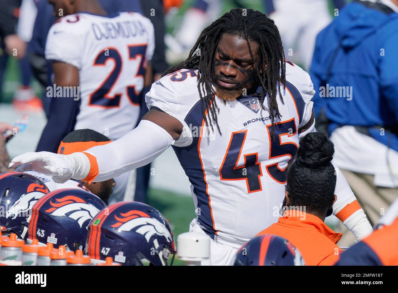 Denver Broncos linebacker Alexander Johnson reaches for his helmet ...