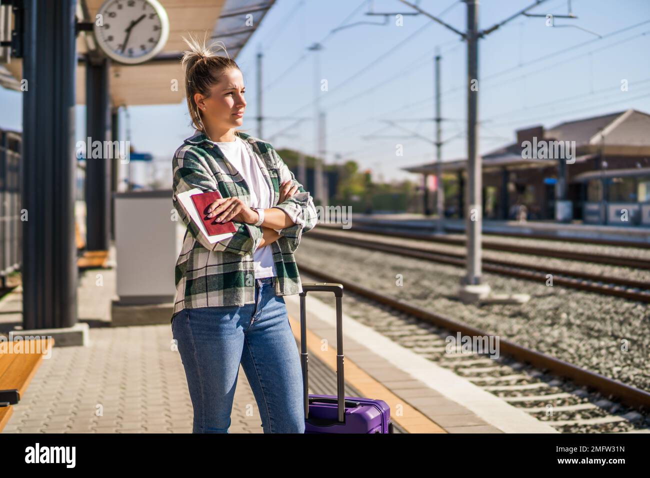 Angry woman standing on a train station Stock Photo - Alamy