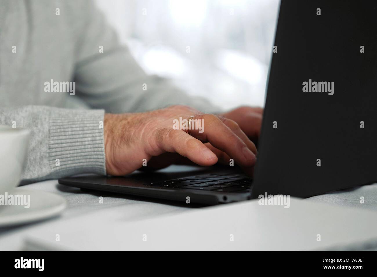 Closeup of senior man hands using laptop. Cropped side view of wrinkled ...