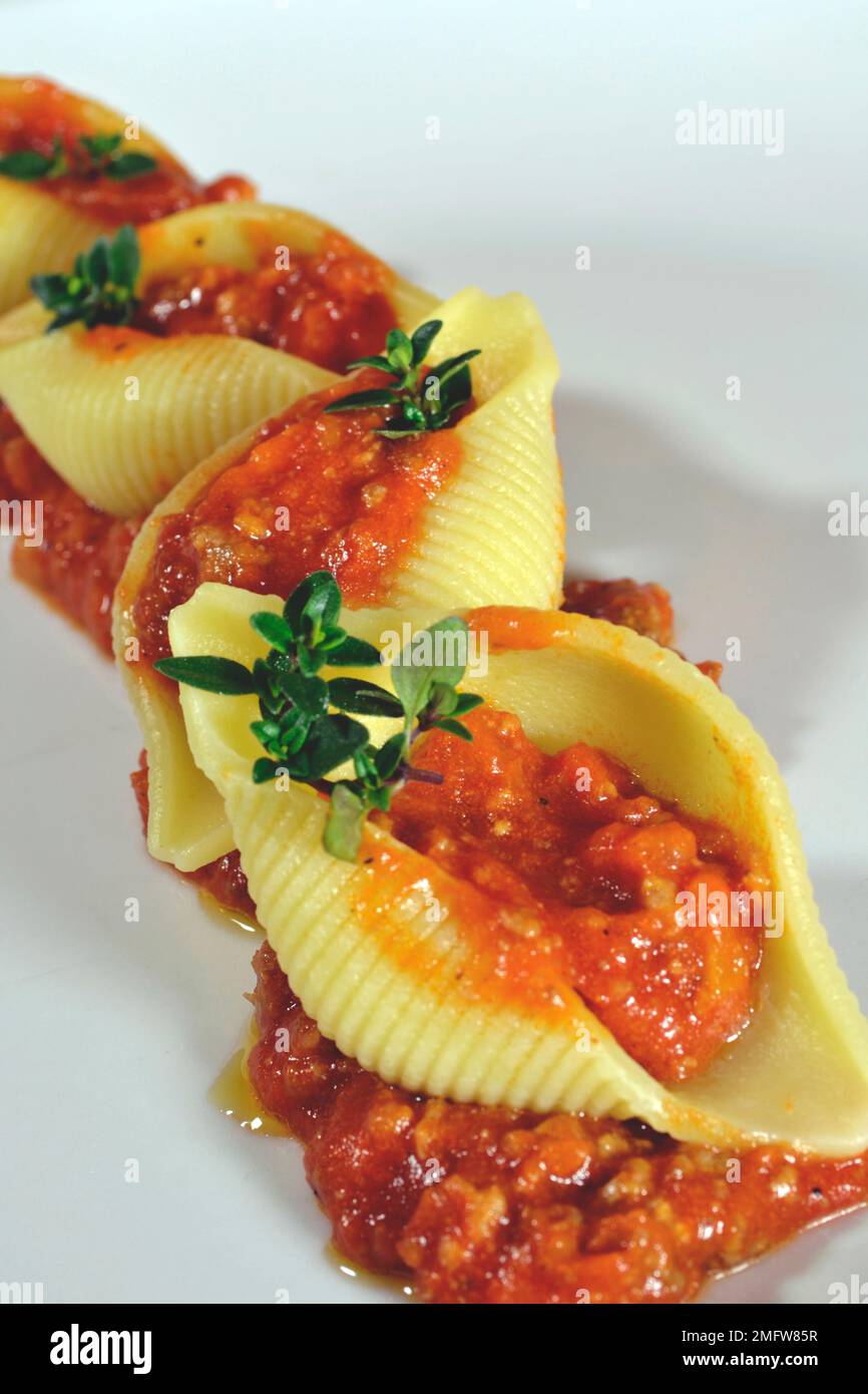 Italian food: Shell-shaped pasta with bolognese ragu and aromatic herbs ...