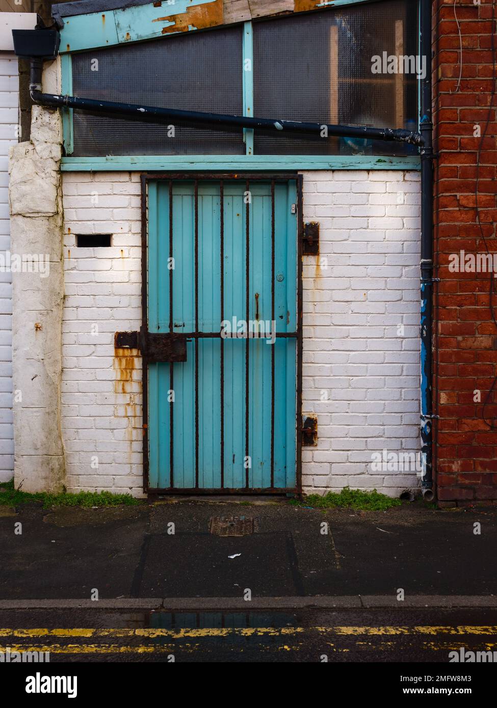 Steel security gate on rear door of scruffy business premises flaky ...