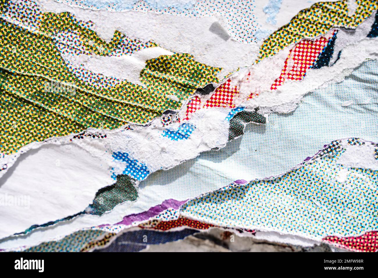 Torn paper collage background on an old poster on a street wall ...