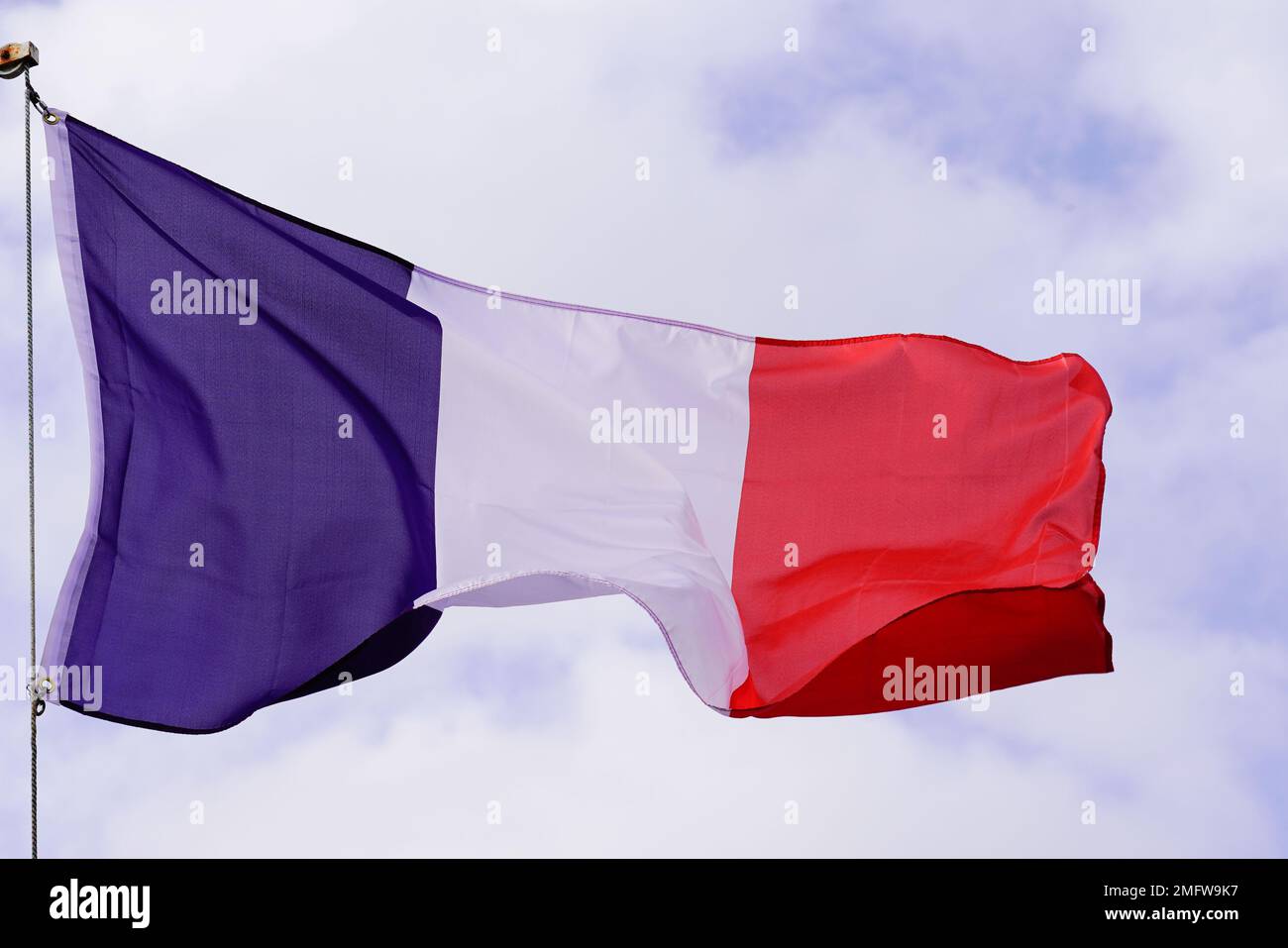 flying red blue white French flag on summer sky Stock Photo - Alamy