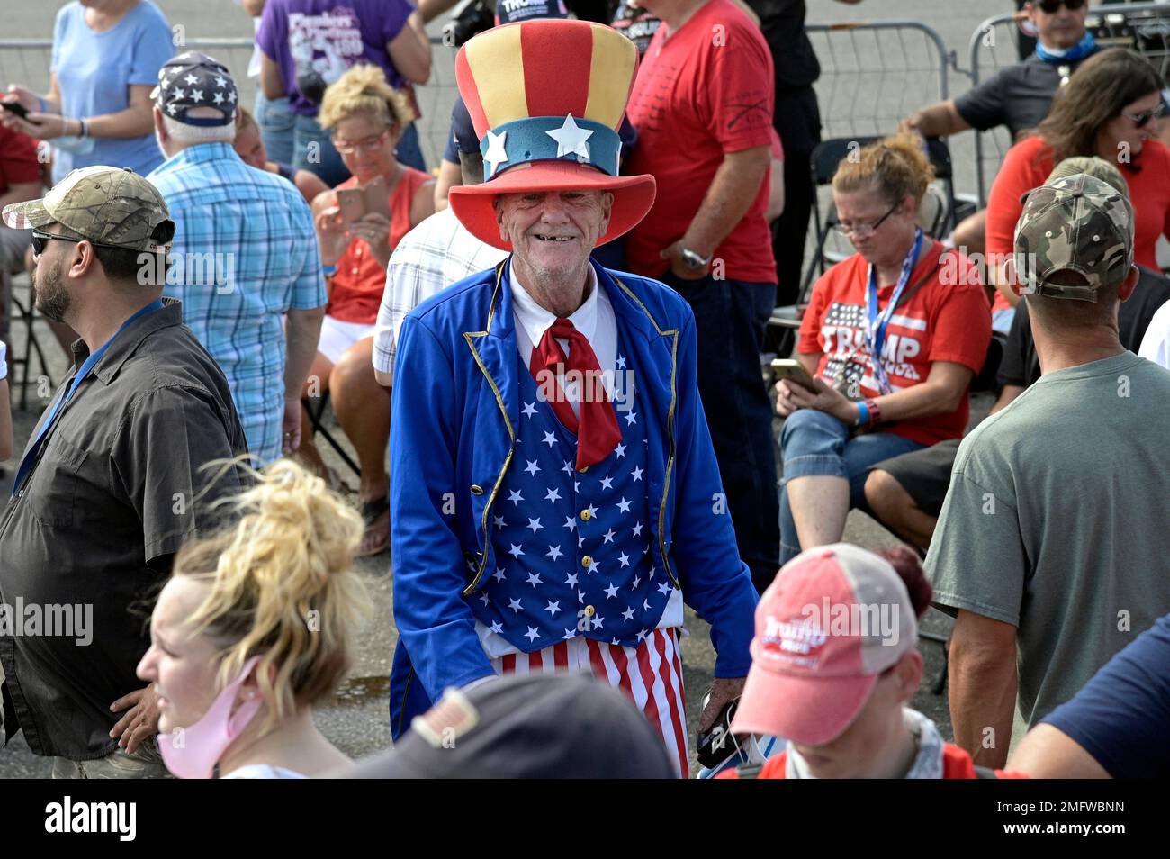 A supporter of President Donald Trump walks through the crowd while ...