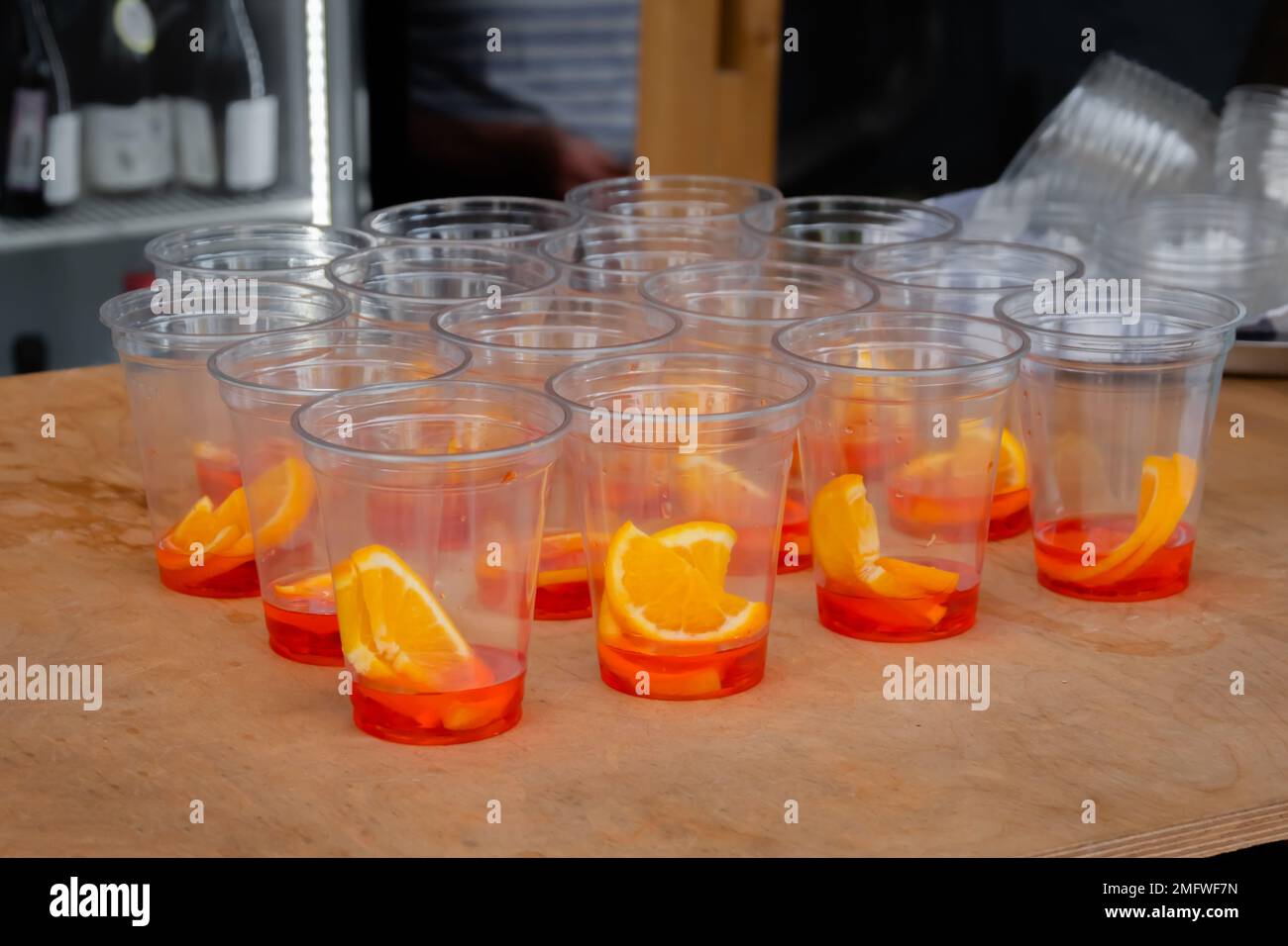 Plastic cups with orange slices and Spritz Aperol cocktail on counter ...