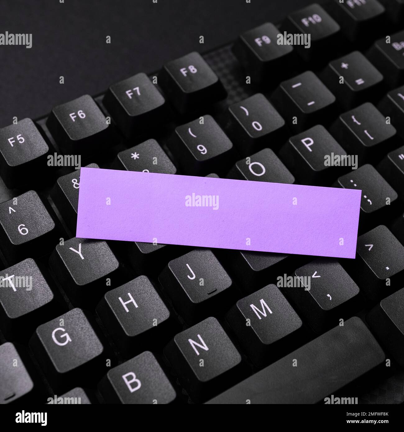 Colored sticker lying on black keyboard. Important information written ...