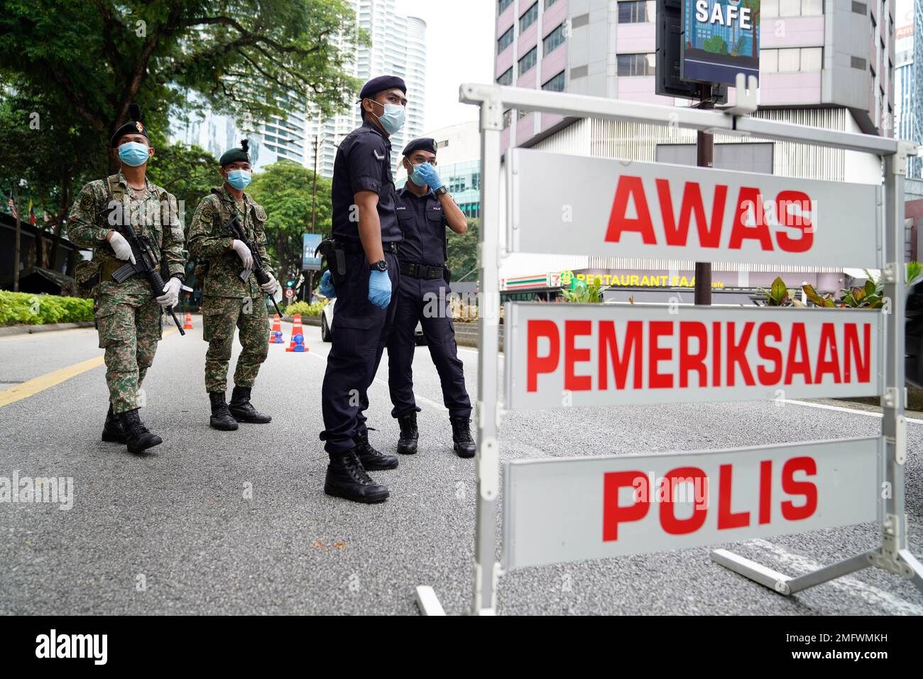 Police and army officers check vehicles at a roadblock to ensure that ...