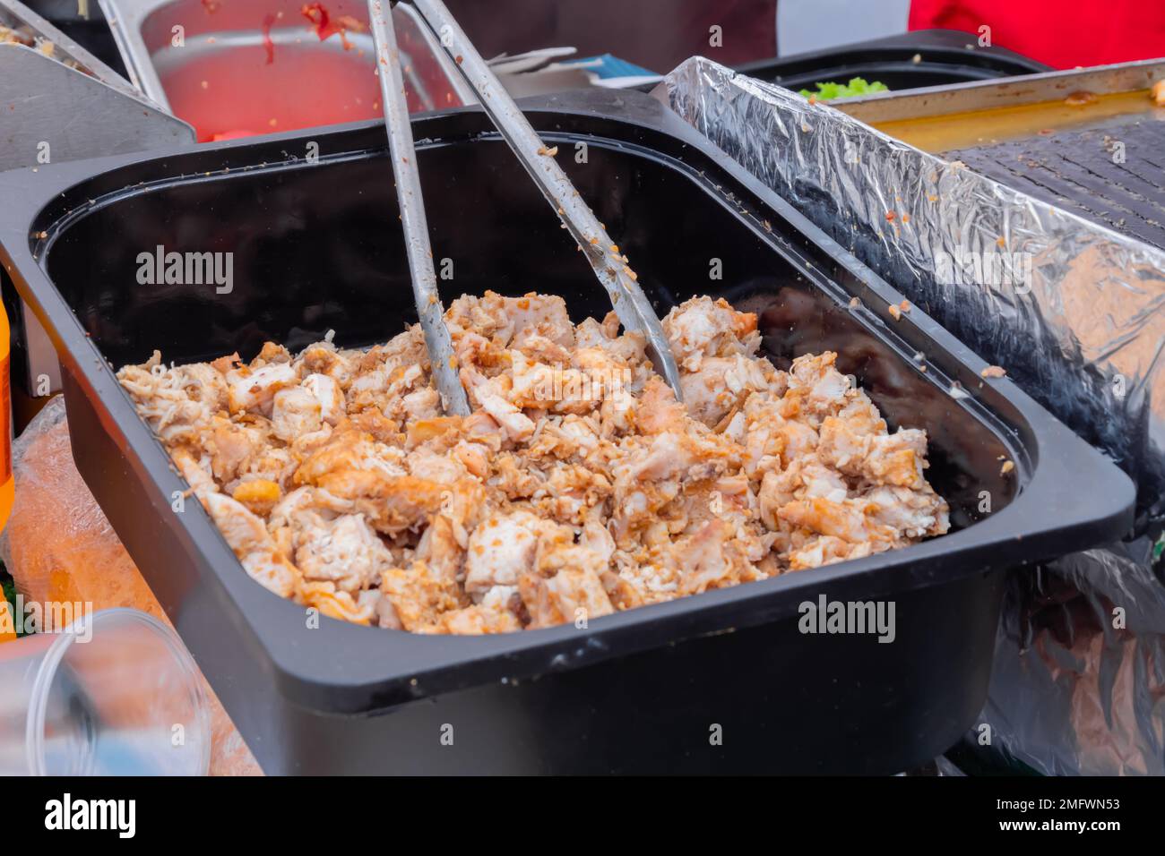 Cooked roasted chicken meat pieces in food container at local food ...