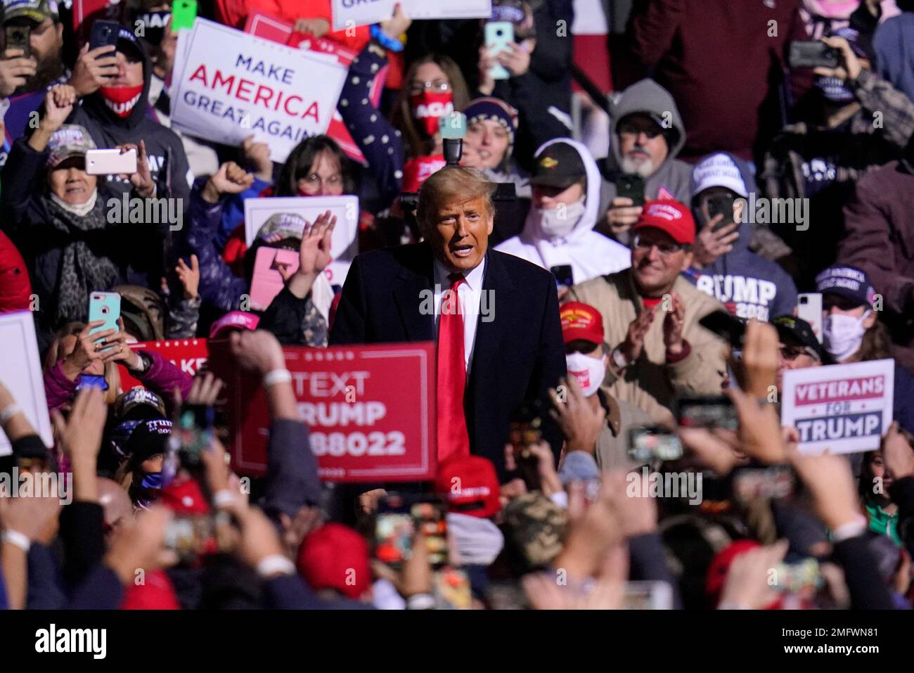 Supporters cheer as President Donald Trump departs a campaign rally at ...
