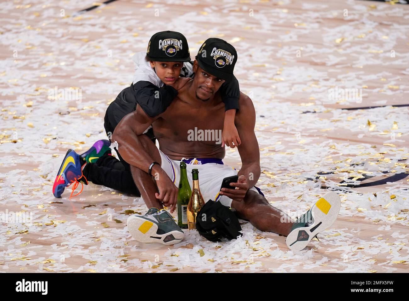 Los Angeles Lakers' Rajon Rondo sits in the confetti with his son Rajon ...