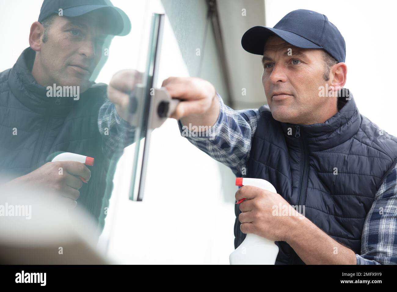 mature handyman cleaning the window Stock Photo - Alamy