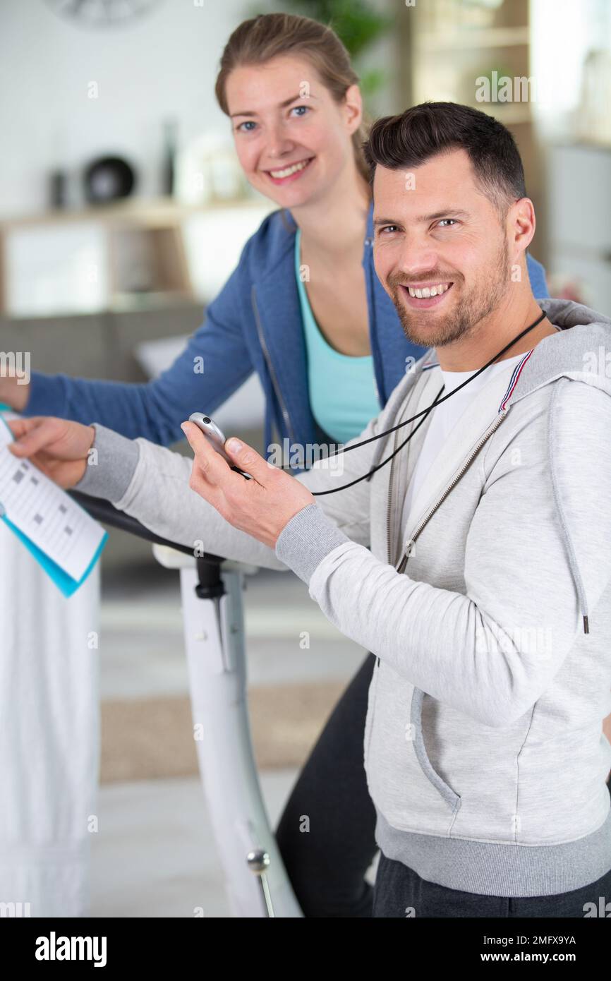 portrait of personal trainer holding stopwatch with female client Stock ...