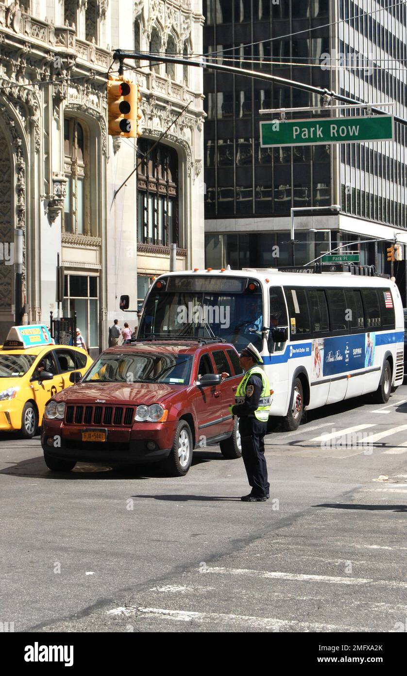 An NYPD police officer standing in busy traffic at an intersection in ...
