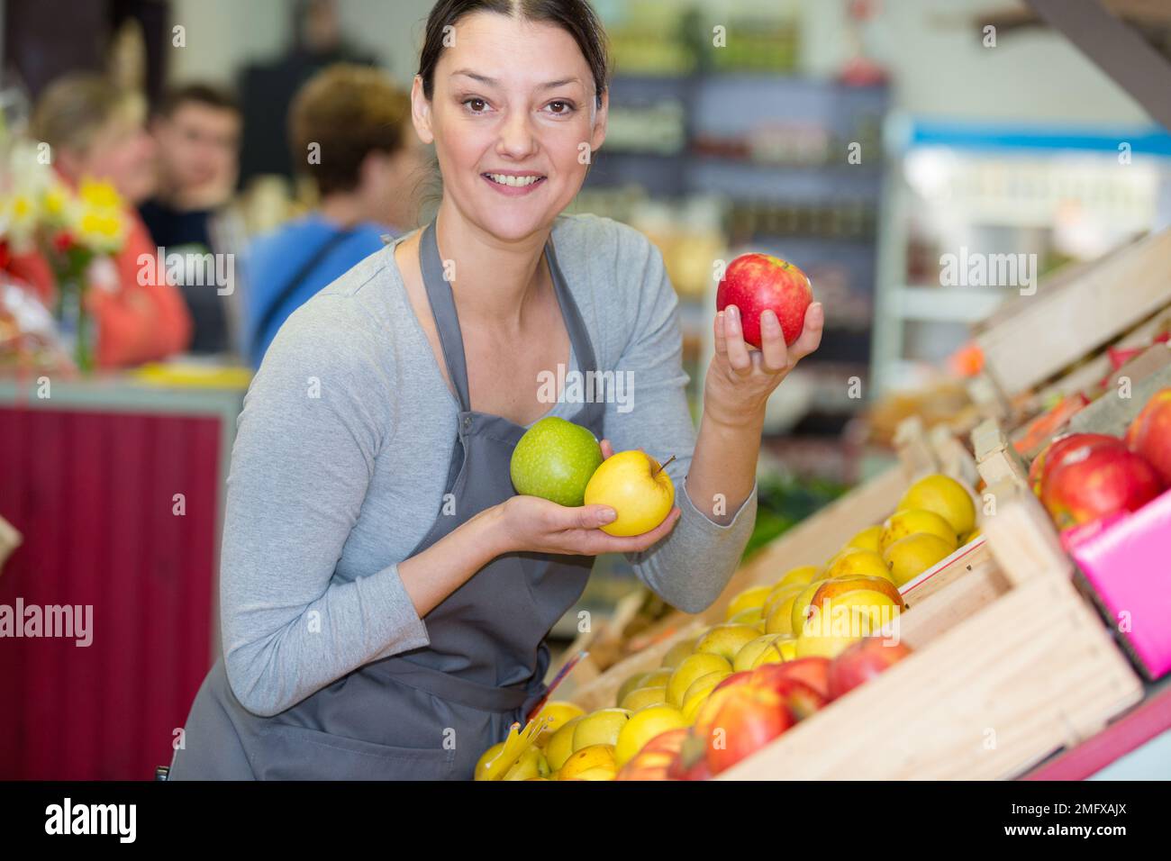 fruit vendor holding three different varieties of apple Stock Photo - Alamy