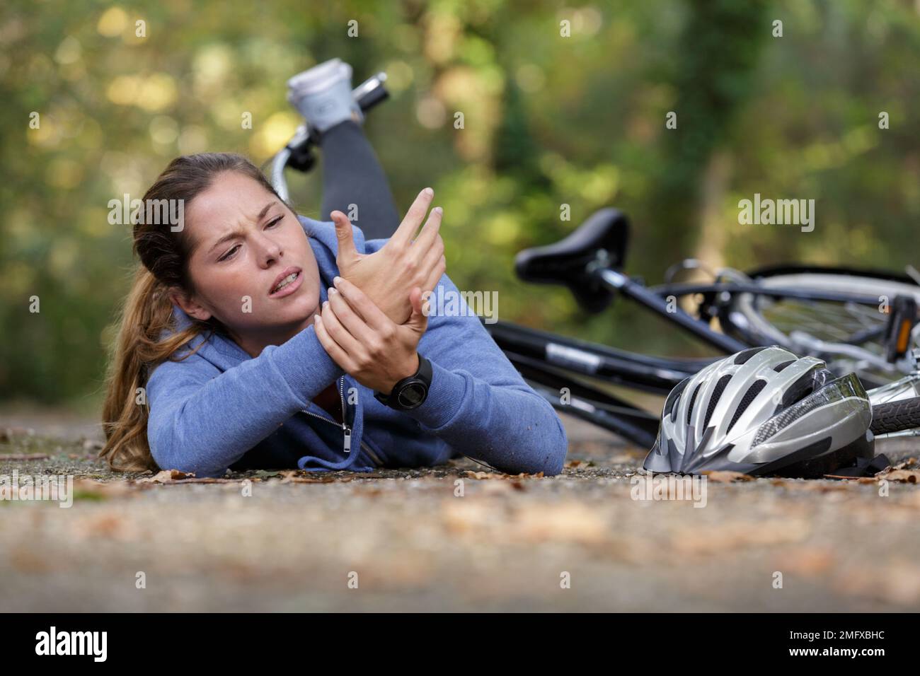 woman on the ground with wrist injury following bicycle accident Stock ...