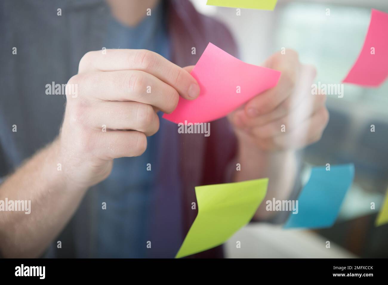 hands sticking a post-it note to the window Stock Photo - Alamy