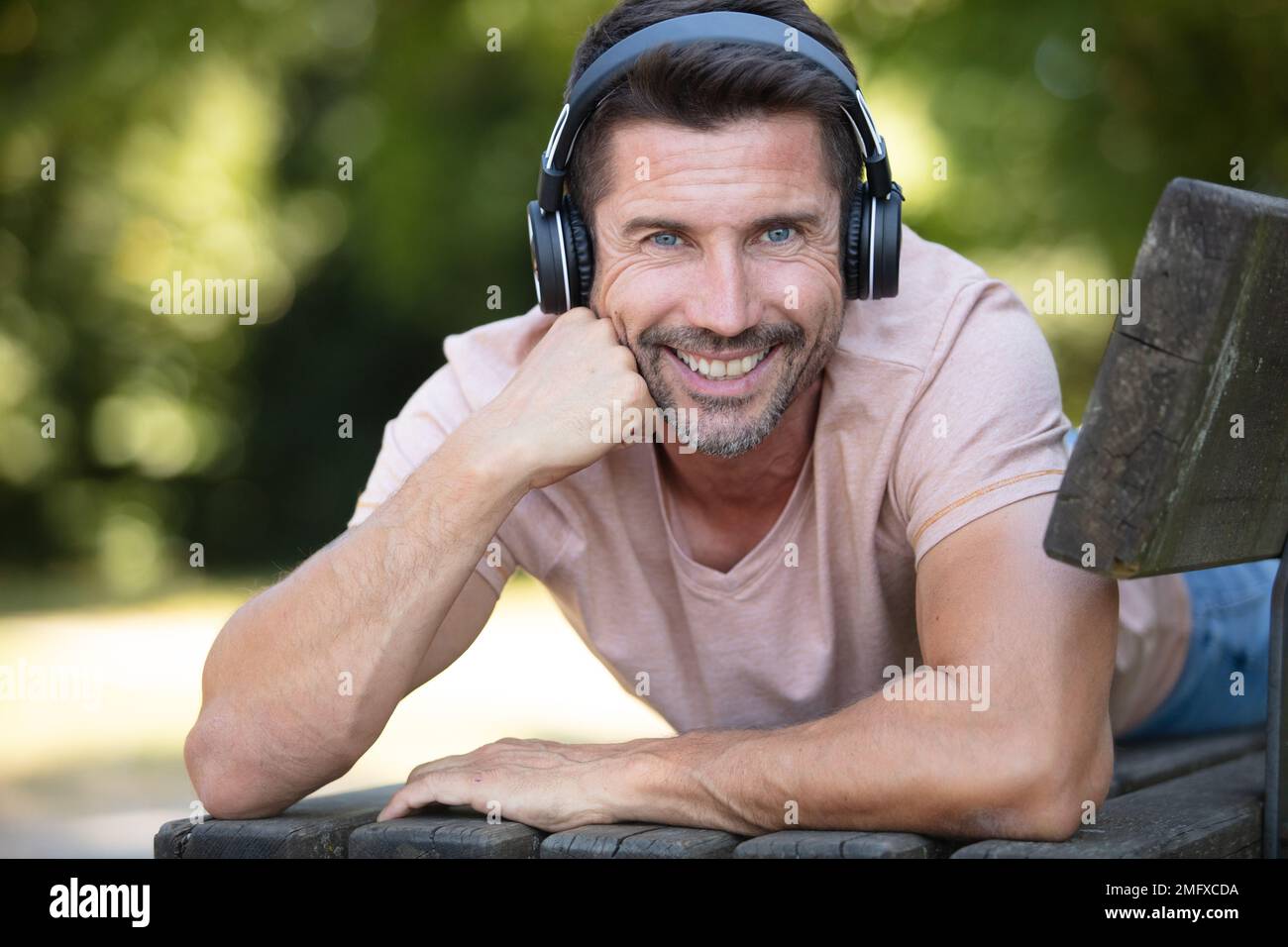 happy handsome man laying on the bench Stock Photo - Alamy