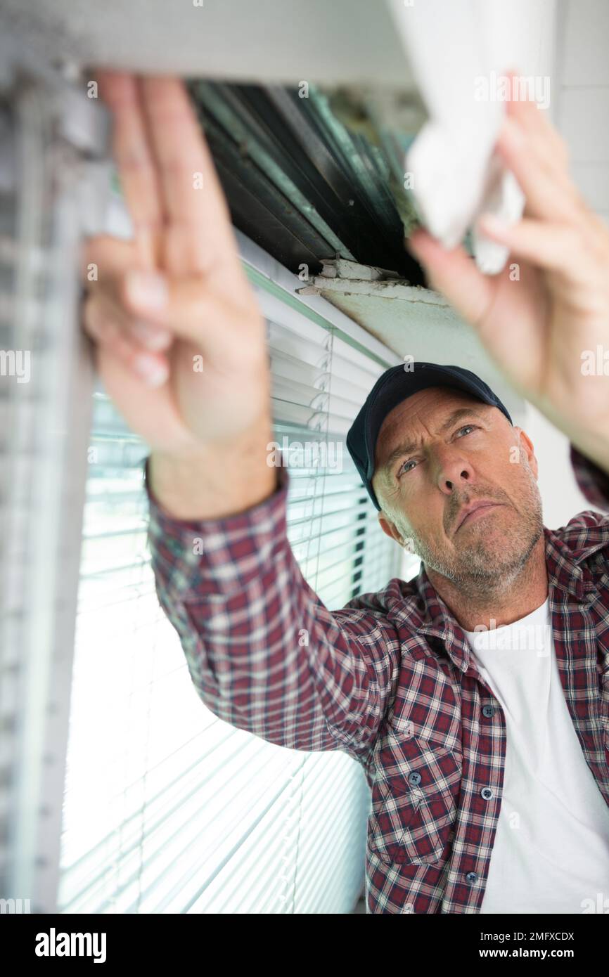 a repairman is fixing a window Stock Photo - Alamy