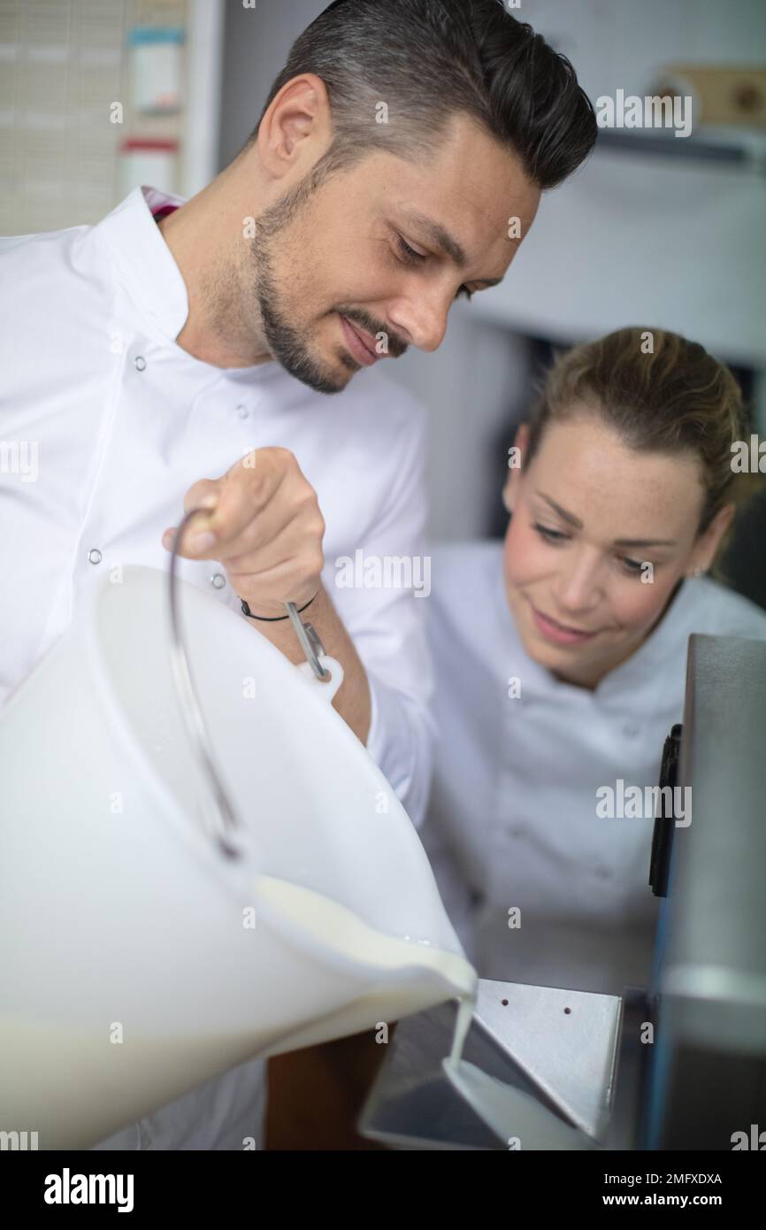 chef pouring liquid into indutrial machine Stock Photo - Alamy