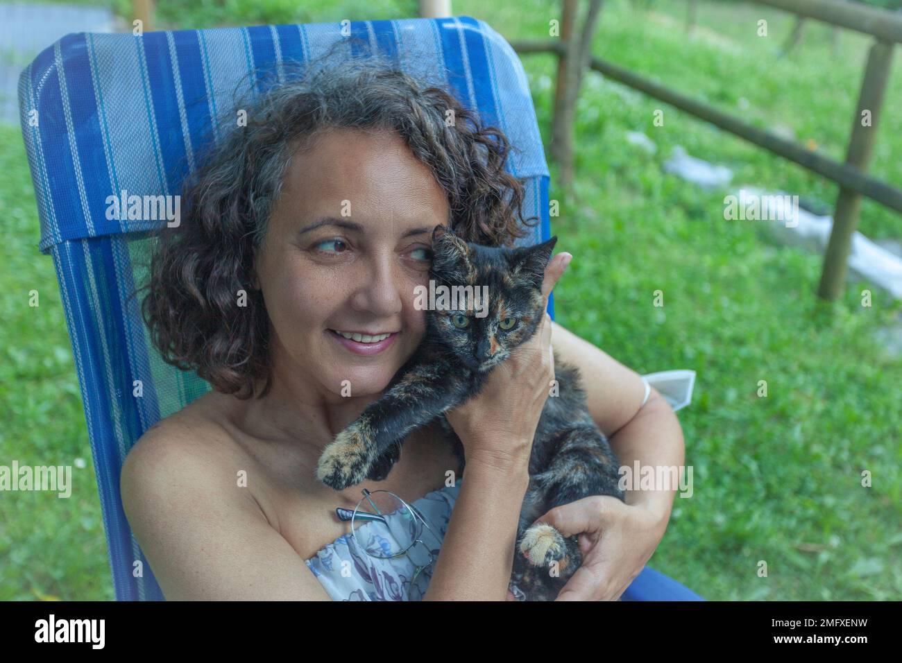 Portrait of woman sitting on chair holding her hair hi-res stock ...