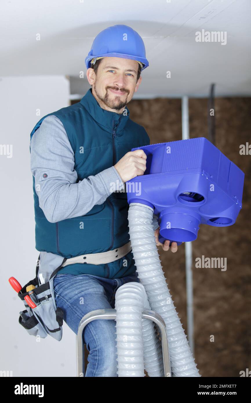 man installing hvac unit in property Stock Photo - Alamy